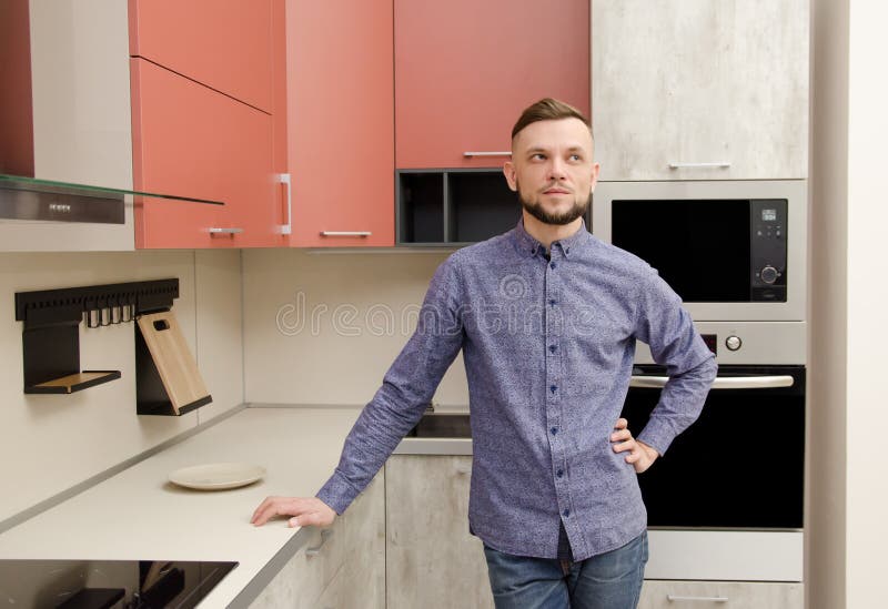Attractive Bearded Man Stands with His Hand on the Countertop in a ...
