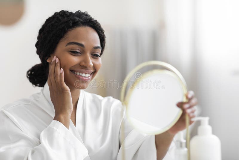 Attractive Black Woman Looking At Mirror And Touching Perfect Skin On