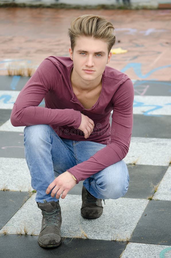 Attractive Blue Eyed, Blond Young Man Sitting on Checkered Floor Stock ... Attractive Blue Eyed, Blond Young Man Sitting on Checkered Floor Stock ...