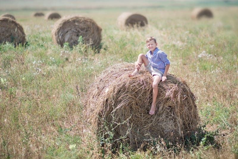 Attractive Boy Sitting on a Haystack and Smiling Stock Image - Image of ...