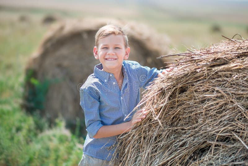 Attractive Boy Sitting on a Haystack and Smiling Stock Photo - Image of ...