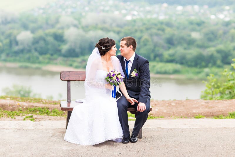Attractive Bride and Groom Sitting on a Bench Stock Photo - Image of ...