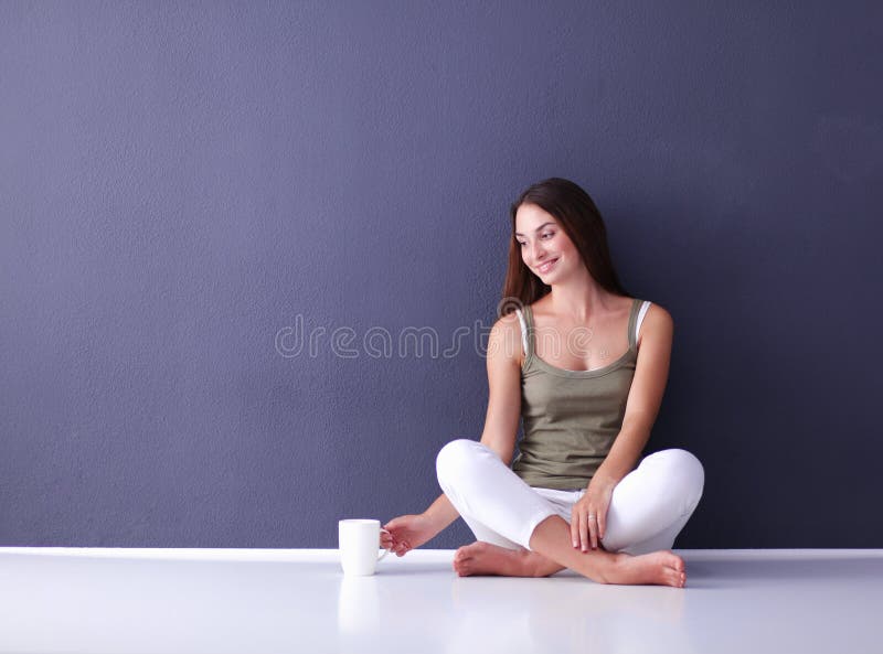 Attractive Caucasian Girl Sitting On Floor With Cup And Tablet Near