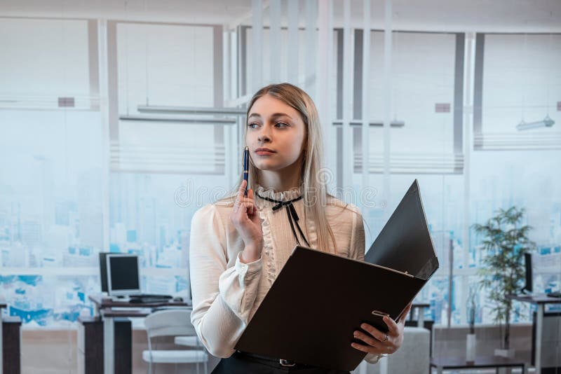 Attractive Woman Standing Alone at the Office and Hold Folder for Paper ...