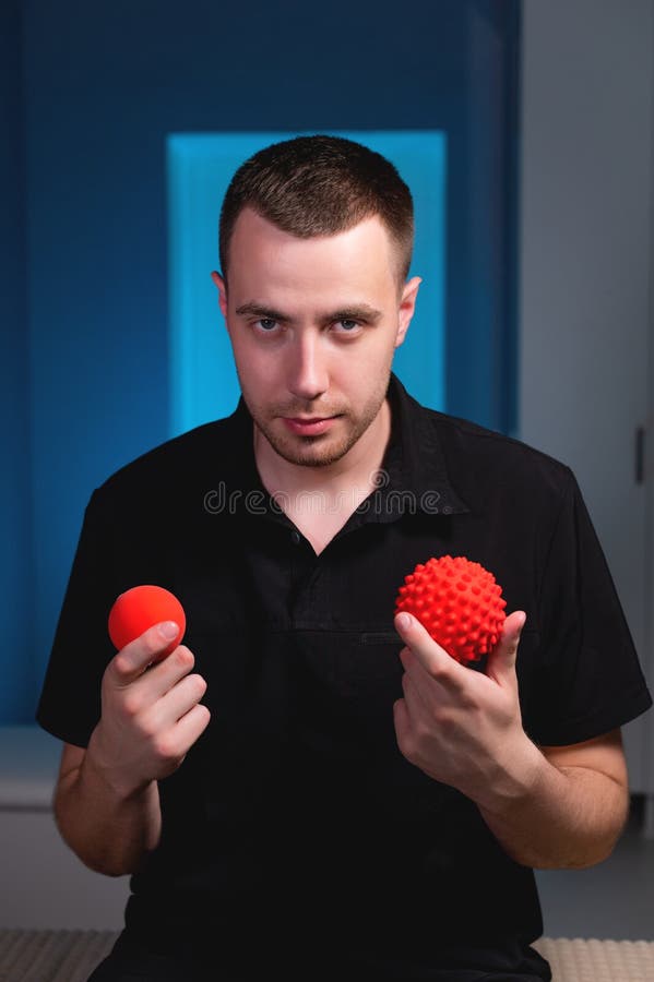 Attractive Caucasian Young Male Masseur Holding Two Massage Balls In