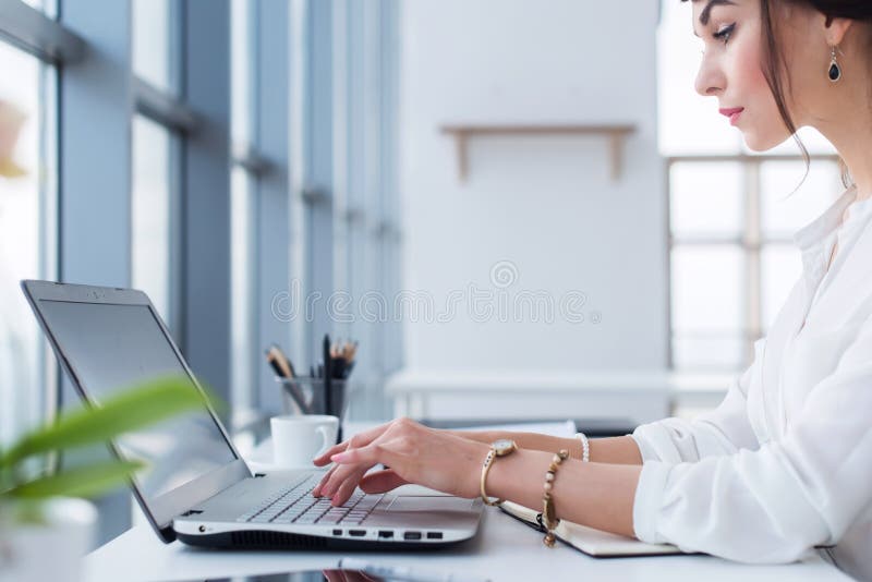 Attractive Female Assistant Working Typing Using Portable Computer Concentrated Looking At
