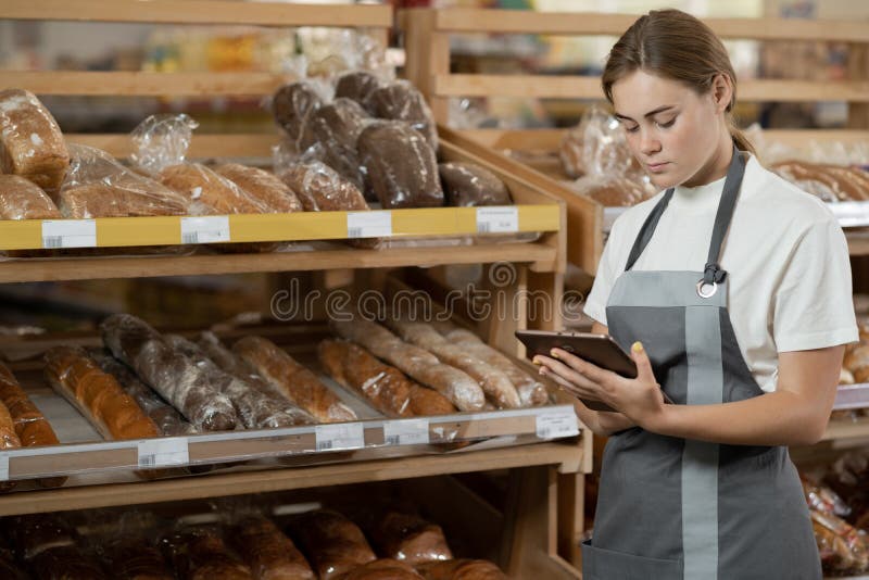 Attractive Female Baker Seller in Apron Using Digital Tablet in Bakery ...