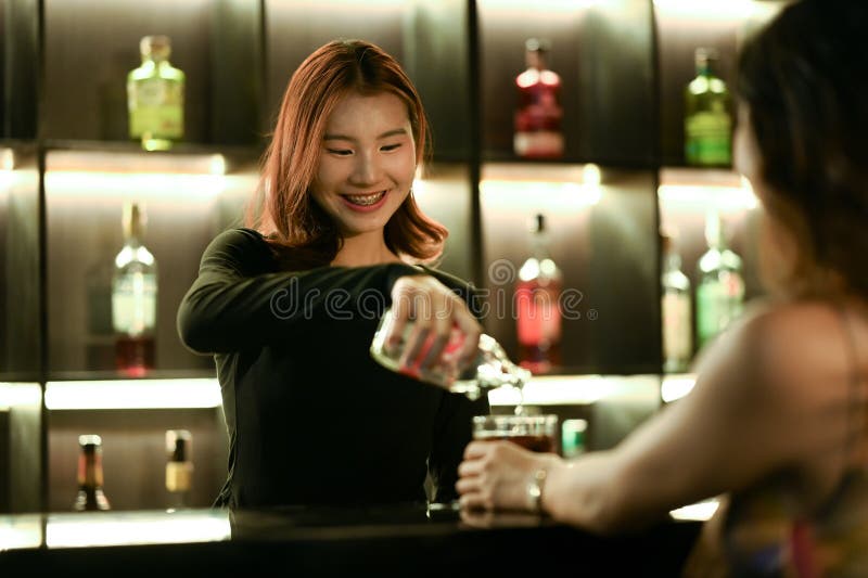 Attractive Female Bartender Standing Behind a Bar Counter Serving Drink ...