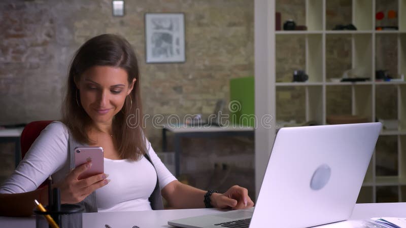 Attractive Female Office Worker Typing on the Laptop Checking the ...