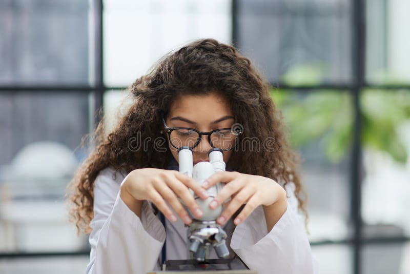 Attractive Female Scientist Looking through a Microscope Stock Image ...