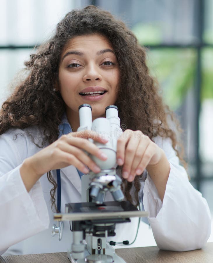 Attractive Female Scientist Looking through a Microscope Stock Image ...