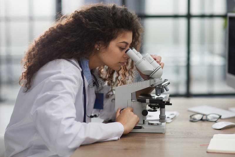 Attractive Female Scientist Looking through a Microscope Stock Photo ...