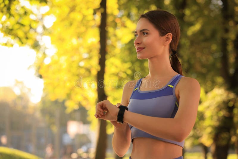 Attractive Happy Woman Checking Pulse after Training in Park on Sunny ...