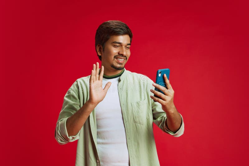 Attractive Indian Man Gesturing Hello while Talking, Using Phone for ...