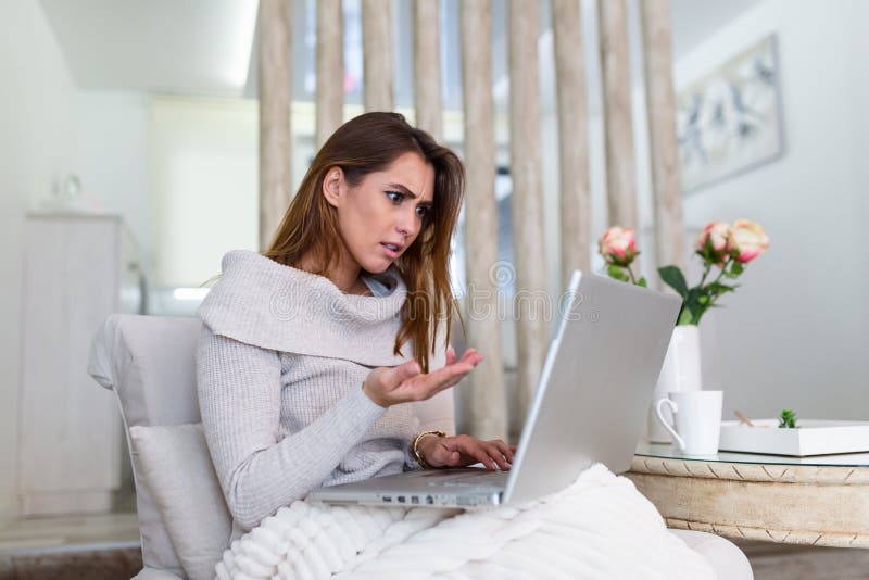 Attractive Mad Woman Sitting at Her Sofa at Home, Looking at Laptop ...