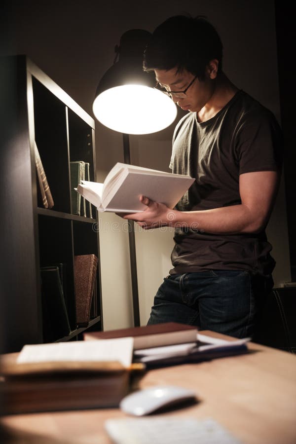 Attractive Man Standing and Reading Book in the Evening Stock Image ...