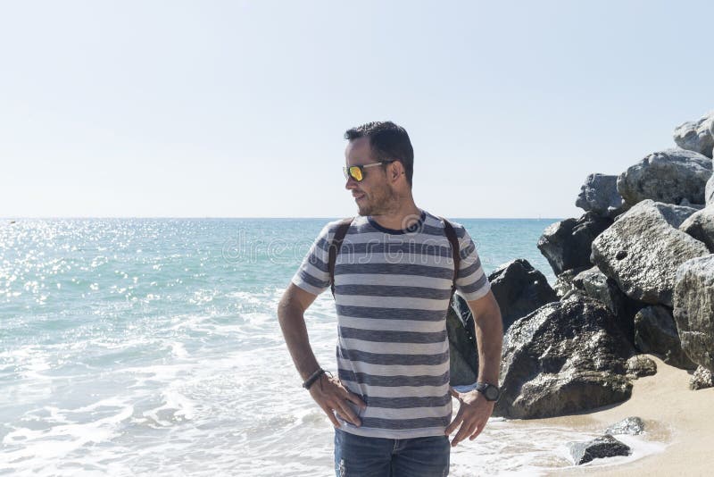 Attractive Bearded Man Standing on the Sea Shore at Sunrise with ... Attractive Bearded Man Standing on the Sea Shore at Sunrise with ...