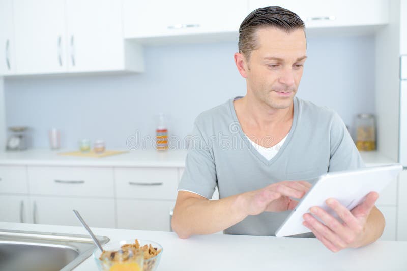 Attractive Man Standing and Using Tablet on Kitchen Stock Image - Image ...