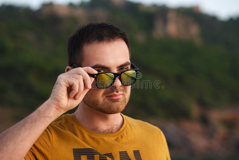 Attractive Man in Yellow Glasses Relaxes on the Beach at Sunset Stock ...