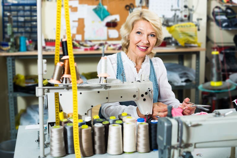 Attractive Mature Woman Tailor Using Sewing Machine Stock Photo - Image ...