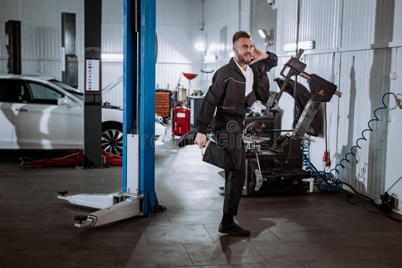 Attractive Mechanic Man in a Modern Service Center Dancing Funny in ...