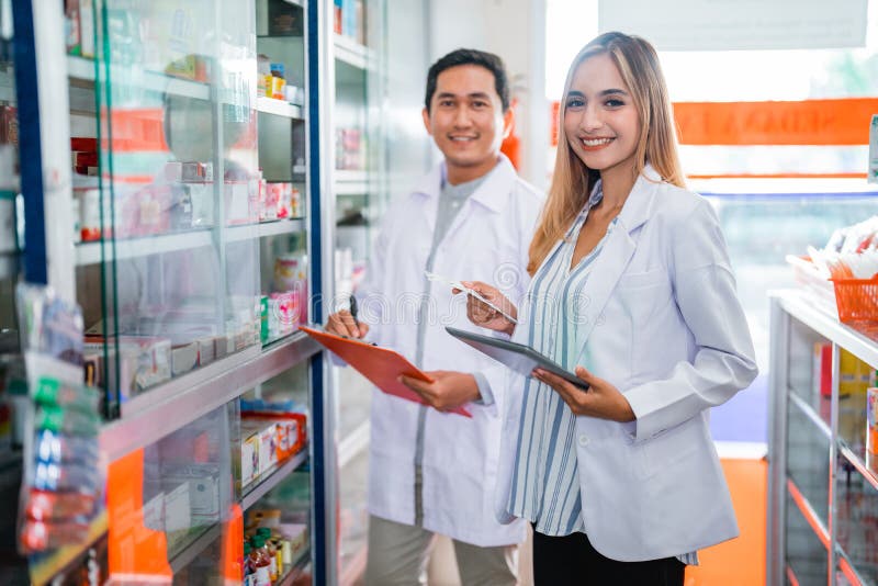 Attractive Pharmacist in Uniform Using Holding Tablet while with ...
