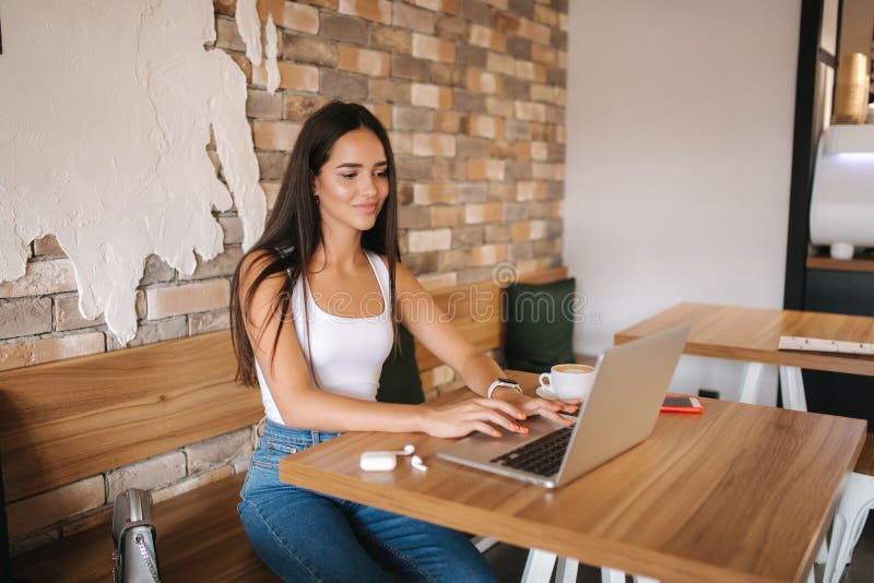 Attractive Smart Girl Working on Laptop in Cafe. Beautiful Girl Using ...
