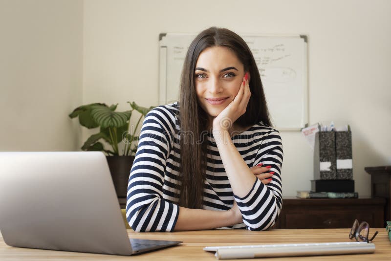 Attractive Smiling Woman Sitting Behind Her Laptop At Home Stock Image