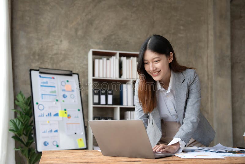 Attractive Young Asian Woman Using Laptop Computer while Standing in a ...