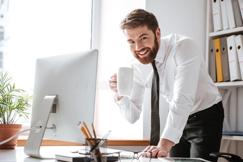 Attractive Young Businessman Drinking Tea and Using Computer. Stock ...