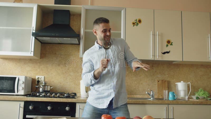 Attractive Young Funny Man Dancing and Singing with Ladle while Cooking ...