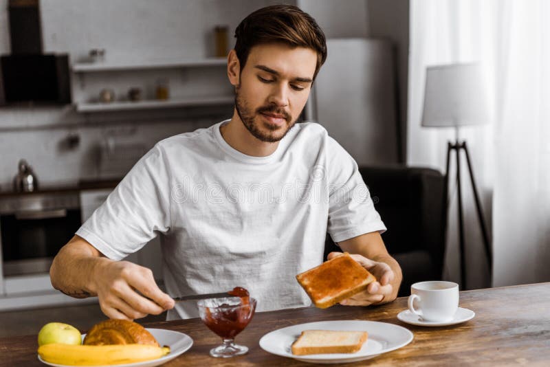Attractive Young Man Applying Jam Onto Toast Stock Image - Image of ...
