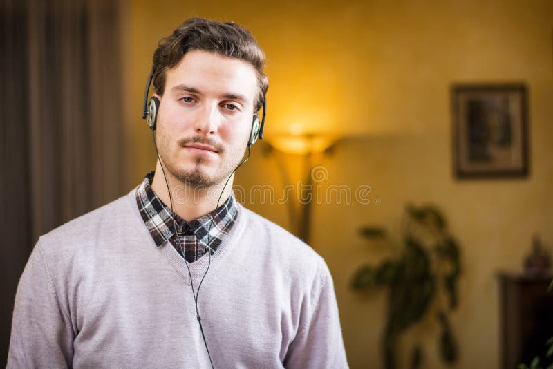 Attractive Young Man Listening To Music On Headphones At Home Stock