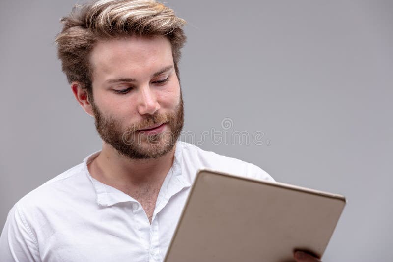 Attractive Young Man Reading on a Tablet-pc Stock Photo - Image of ...
