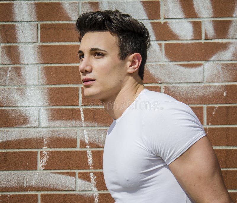 Attractive Young Man Standing Against Brick Wall Stock Image - Image of ...