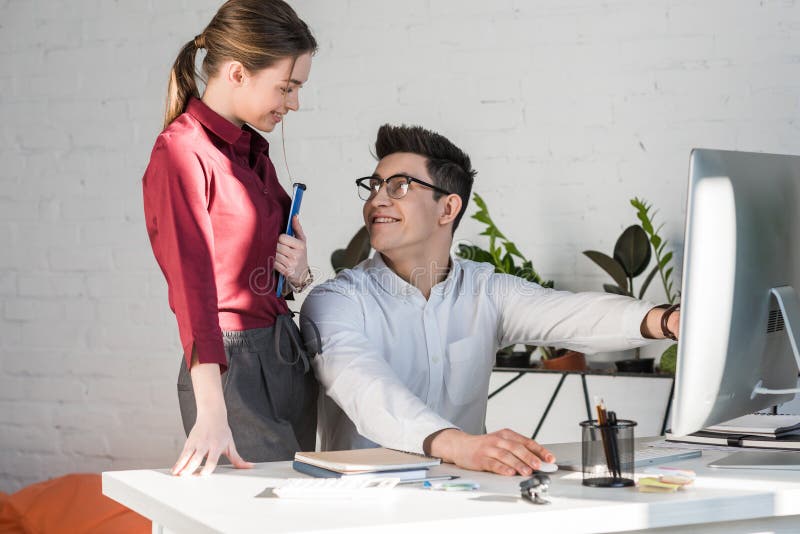 Attractive Young Managers Working with Computer Together at Workplace ...