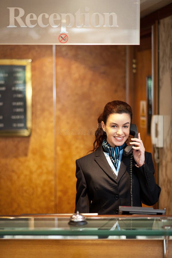 Receptionist Greeting Man at Front Desk Stock Image - Image of woman ...