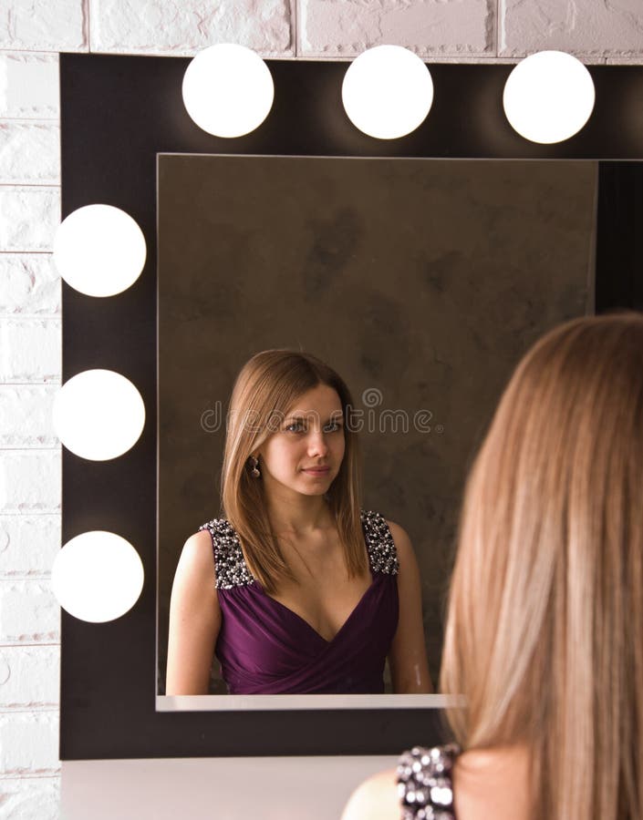 An Attractive Young Woman Looking in the Mirror Stock Photo - Image of ...