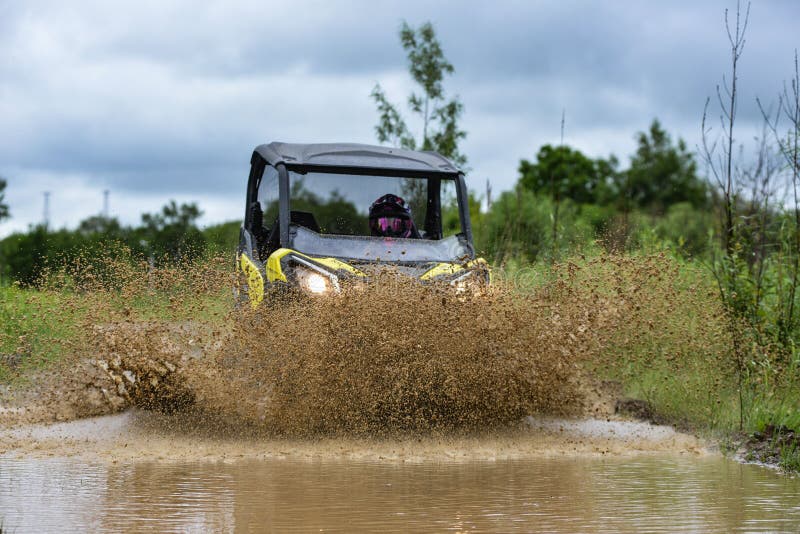 ATV Brp is Moving on a Muddy Puddle Making Splashes Stock Image - Image ...