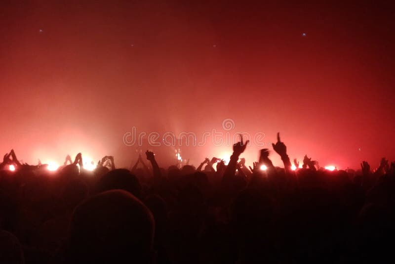 Audience with Hands Raised at a Concert and Lights Streaming from the ...