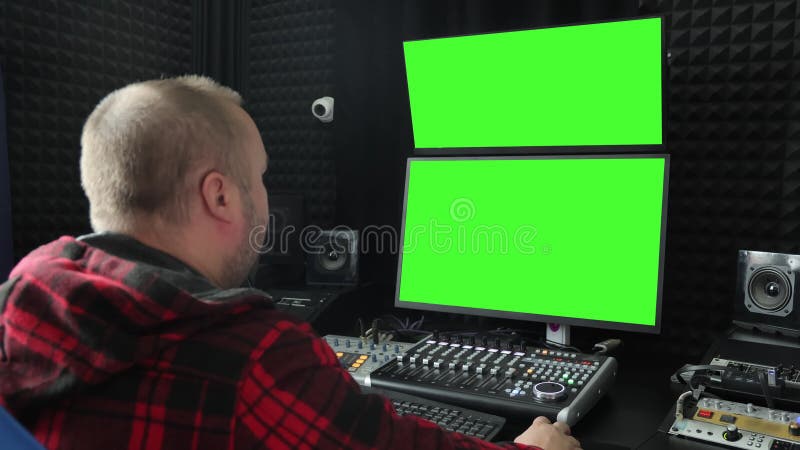 Audio Engineer at Workstation with Green Screen Monitors, Rear View of ...