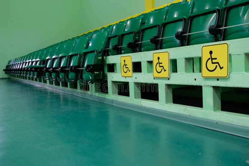 Auditorium with Rows of Green Seating. Disabled Areas are Marked with ...