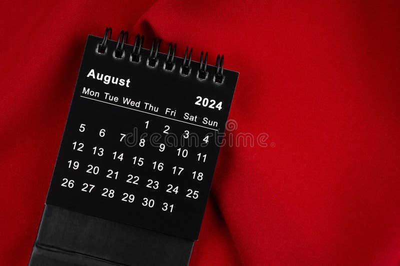 August 2024 Black Spiral Desktop Calendar on Red Fabric Stock Image ...