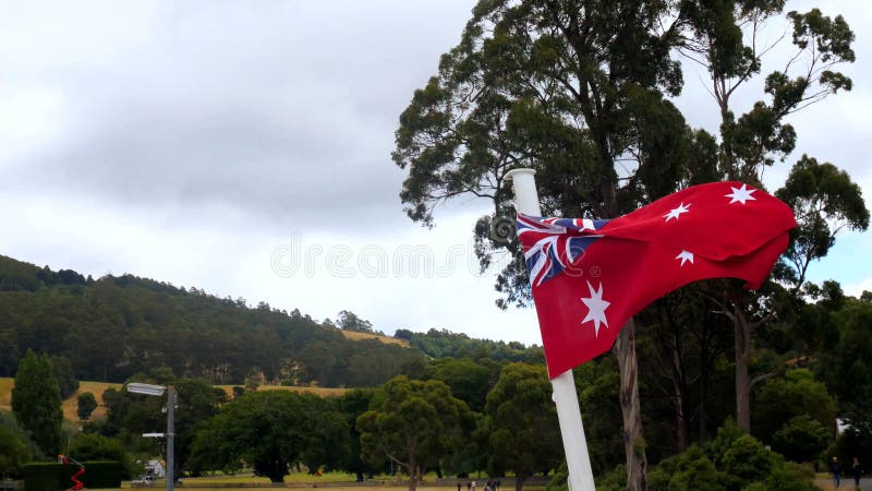 Australian Red Ensign Flag Waving in the Wind with Lush Green Trees in ...