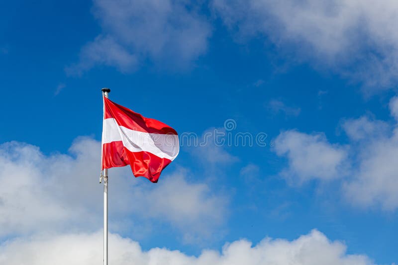 The Austrian Red White Red National Flag Flutters Against a Blue Alpine ...