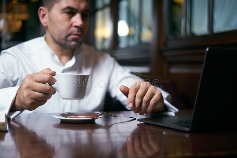 Businessman Having Coffee in a Cafe while Working on Laptop Stock Image ... Businessman Having Coffee in a Cafe while Working on Laptop Stock Image ...