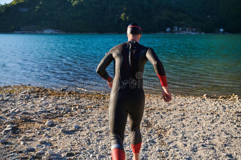 Authentic Triathlon Athlete Getting Ready for Swimming Training on Lake ...