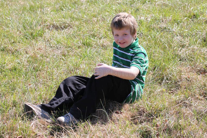Autistic Boy Sitting in a Field Stock Photo - Image of sitting, grass ...