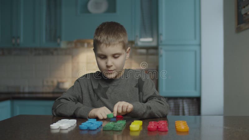 Autistic Boy Sorting Plastic Caps by Colors on the Table at Home. Kid ...