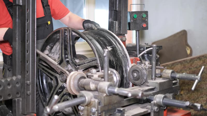 Auto Mechanic Aligns Car Rims. Tire Fitting Tire Machine for Rolling ...